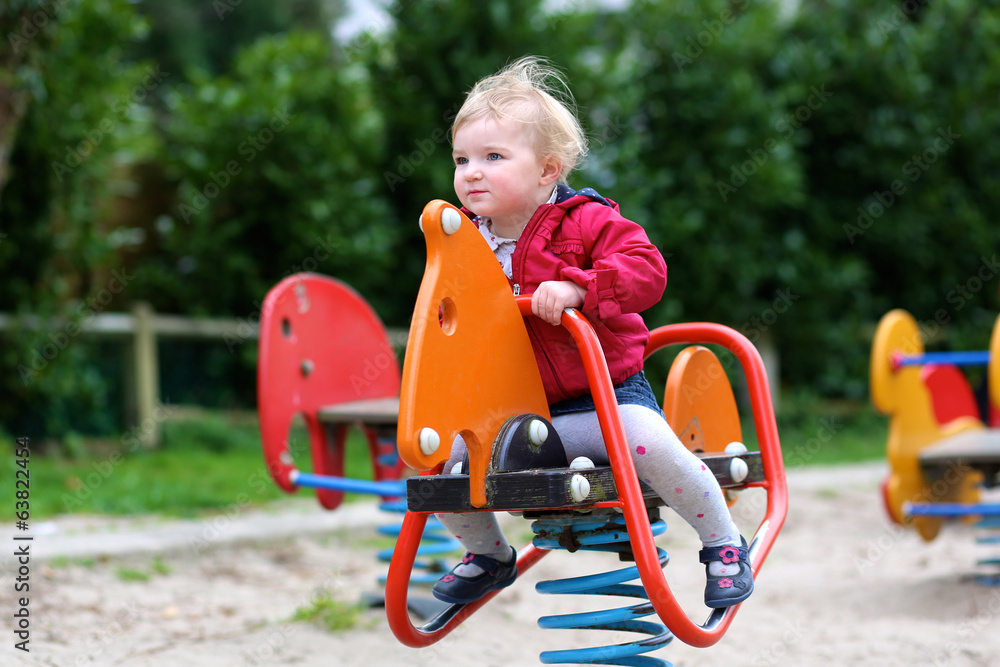 Little girl on spring horse at playground Stock Photo | Adobe Stock