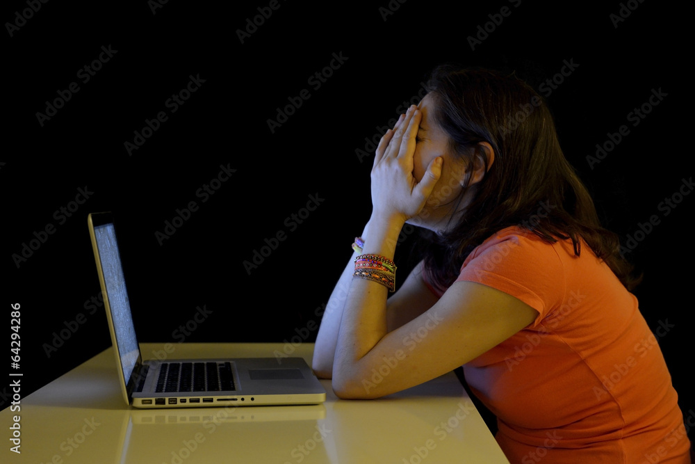 Young student woman at desk sad into tears with computer Stock-Foto ...