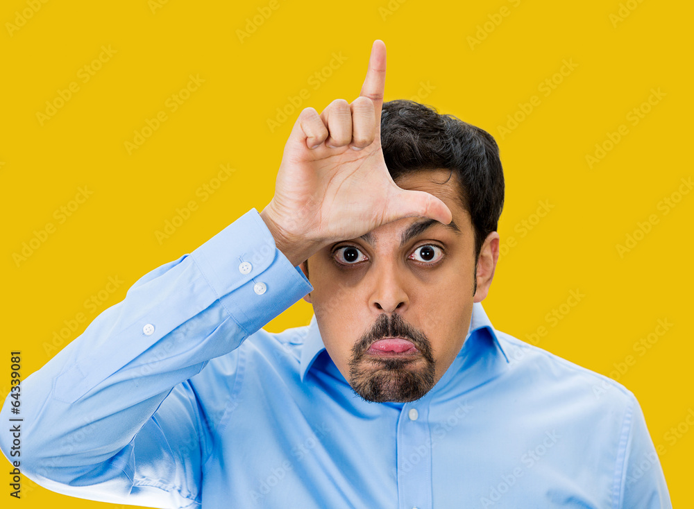 Bully guy giving Loser hand gesture on yellow background Stock Photo ...