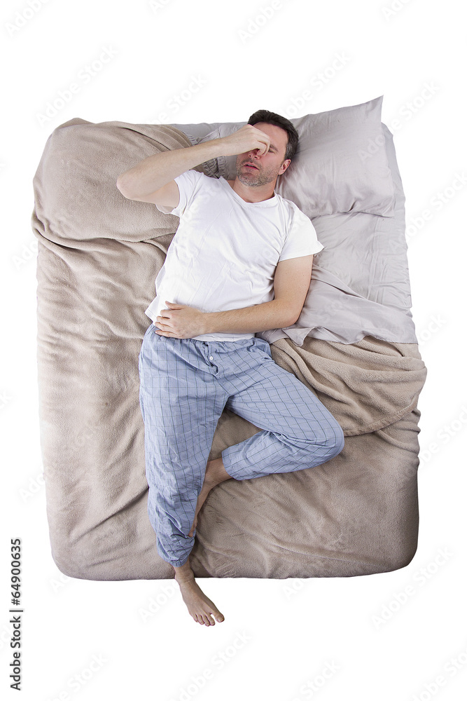 Foto de top view of sleep deprived man on a bed do Stock | Adobe Stock