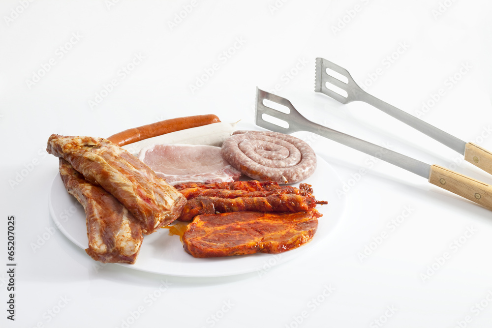 Gegrilltes Fleisch in der Platte mit einer Zange auf weißem Hintergrund ...