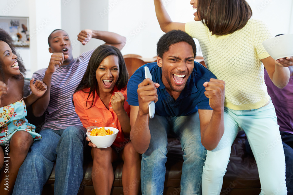Group Of Friends Sitting On Sofa Watching TV Together Stock Photo ...
