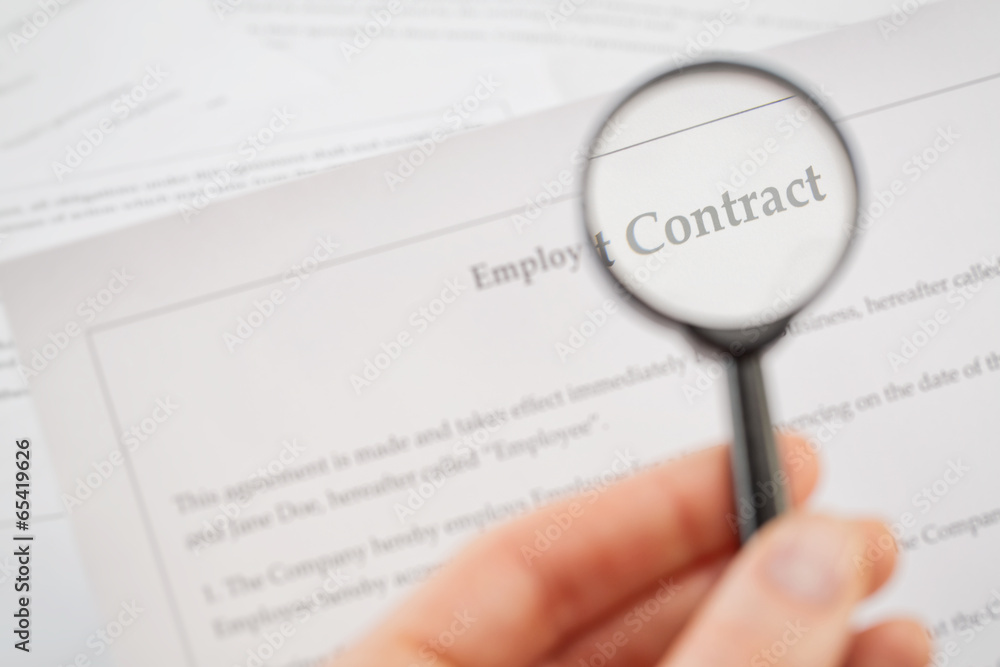 Analyzing Contract with Magnifying Glass Stock Photo | Adobe Stock