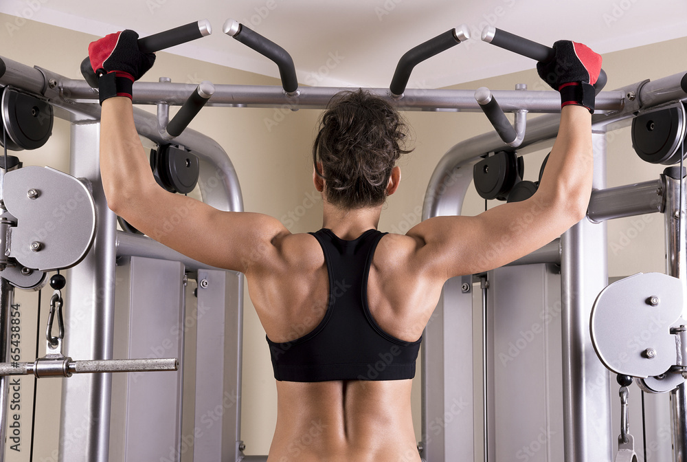 Athletic young woman showing muscles of the back. Stock Photo | Adobe Stock