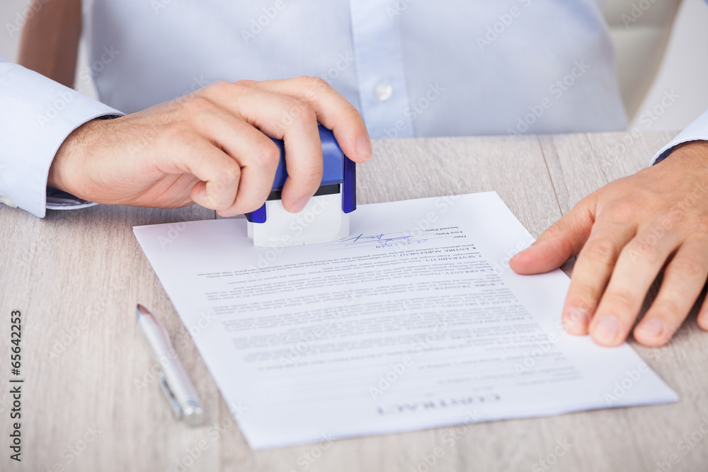 Cropped Image Of Businessman Stamping Contract Paper Stock Photo ...