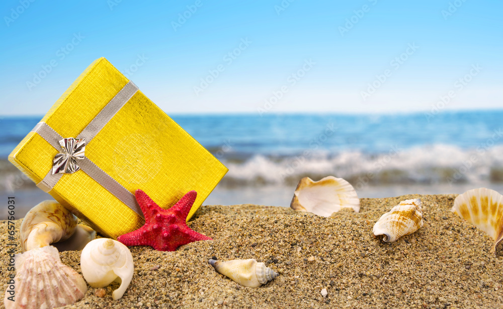 Gold gift box on sand with summer sea background Stock Photo | Adobe Stock