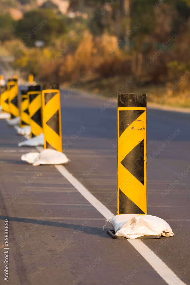 Yellow road signs in a row held down with sandbags Stock Photo | Adobe ...