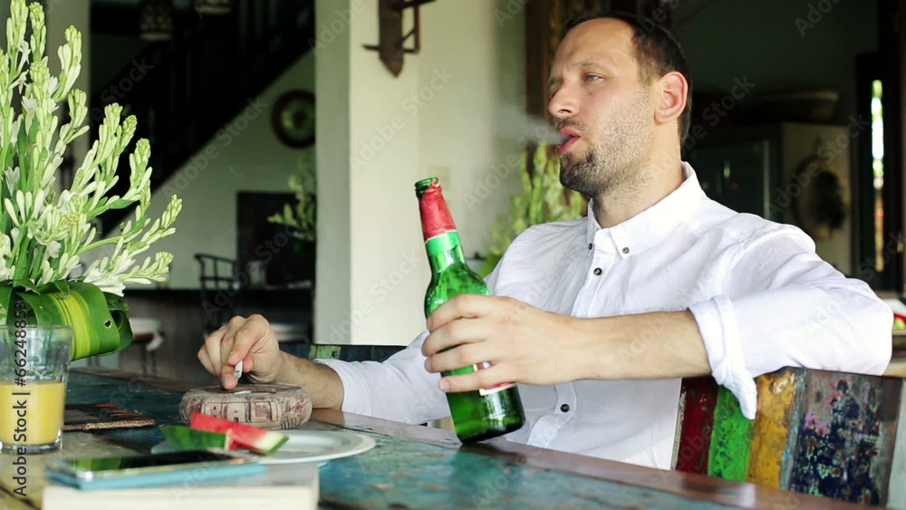 Man smoking cigarette and drinking beer at home Stock Video | Adobe Stock