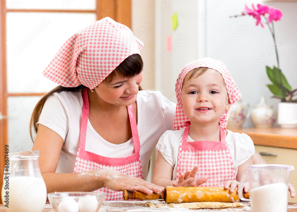 kid girl with her mother cook and roll out the dough Stock Photo ...