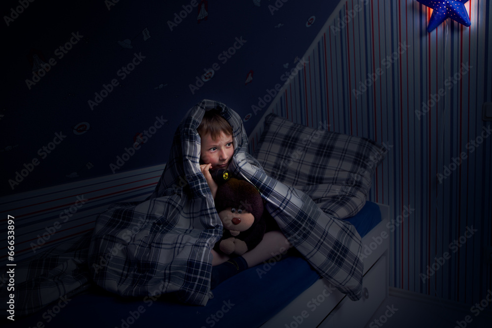 Kind versteckt sich unter der Decke Photos | Adobe Stock