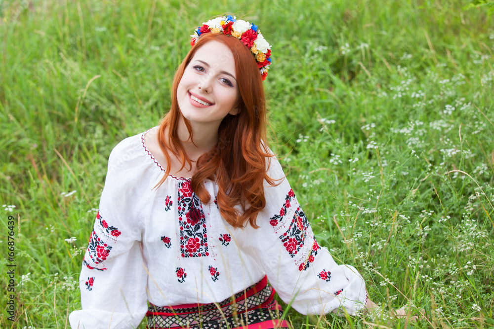 Redhead girl in nationac ukrainian clothes on the green grass. Stock 写真 ...