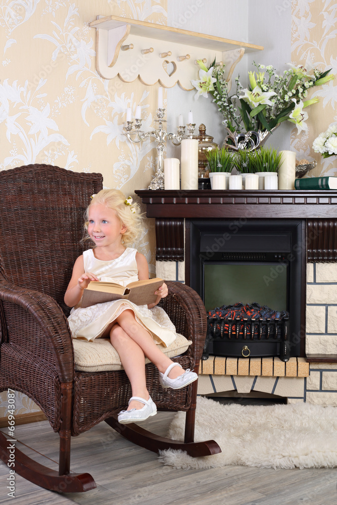 Little girl in white dress sits in wicker rocking chair Stock Photo ...