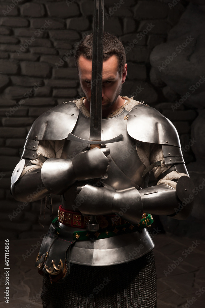 Medieval knight kneeling with sword Stock Photo | Adobe Stock