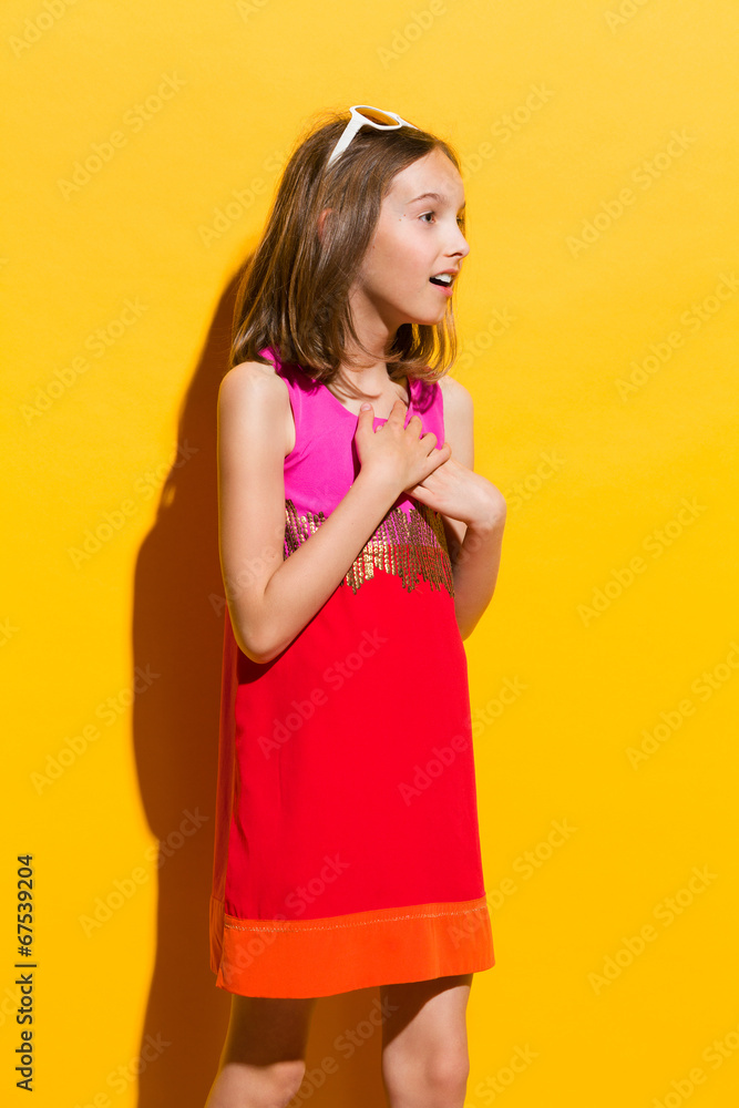 Delighted little girl with hands on chest Stock Photo | Adobe Stock