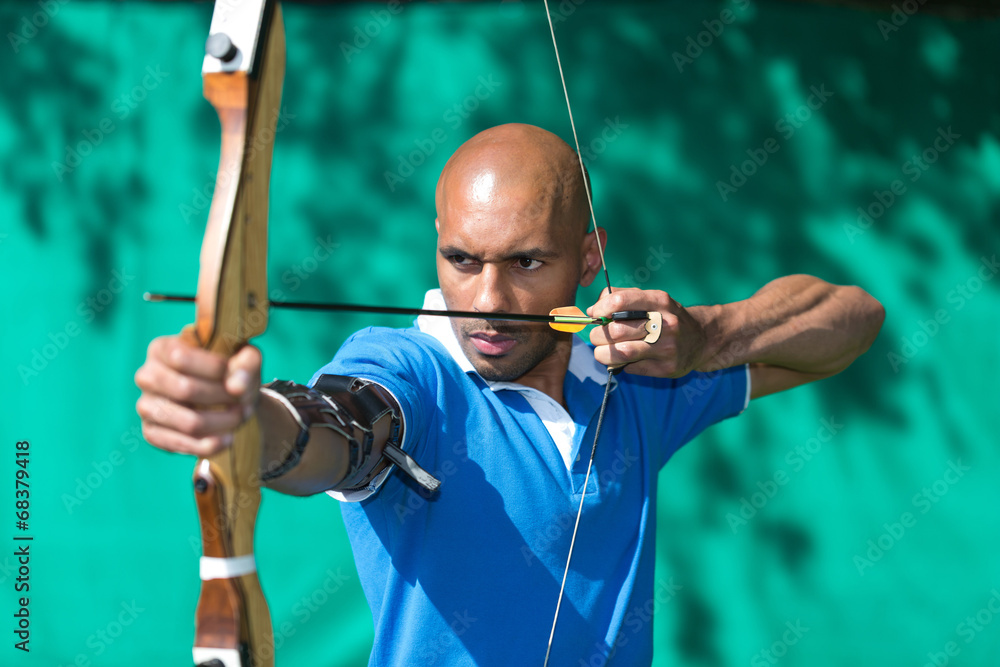 Archer aiming at target with bow and arrow Stock Photo | Adobe Stock