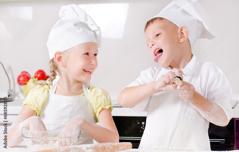 Happy little boy and girl cooking in the kitchen Stock Photo | Adobe Stock