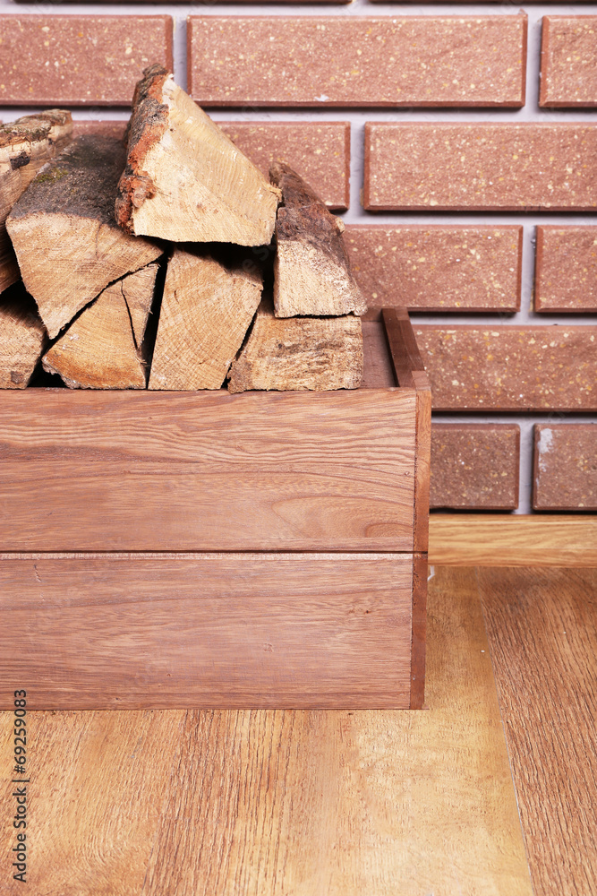 Wooden box of firewood on floor on brick background Stock Photo | Adobe ...