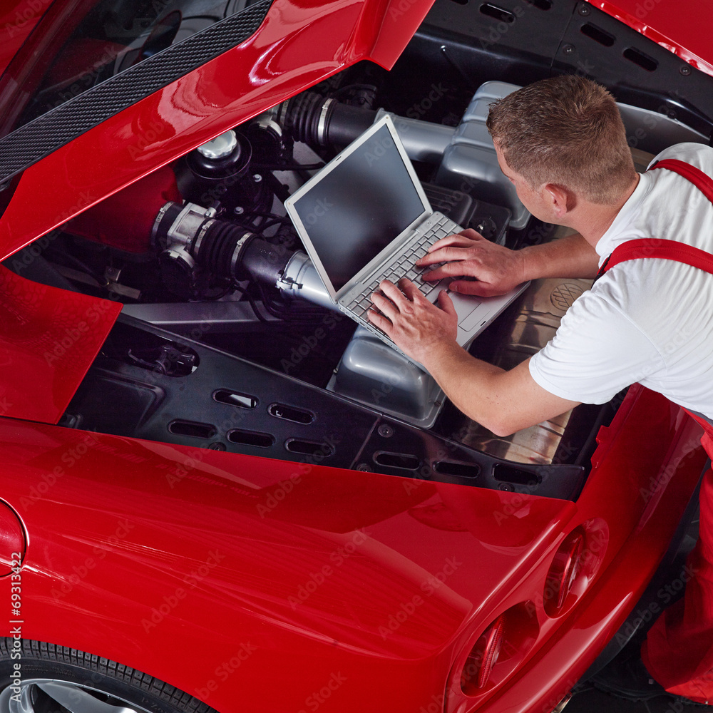 Mechanic is tuning the engine of a car Stock Photo | Adobe Stock