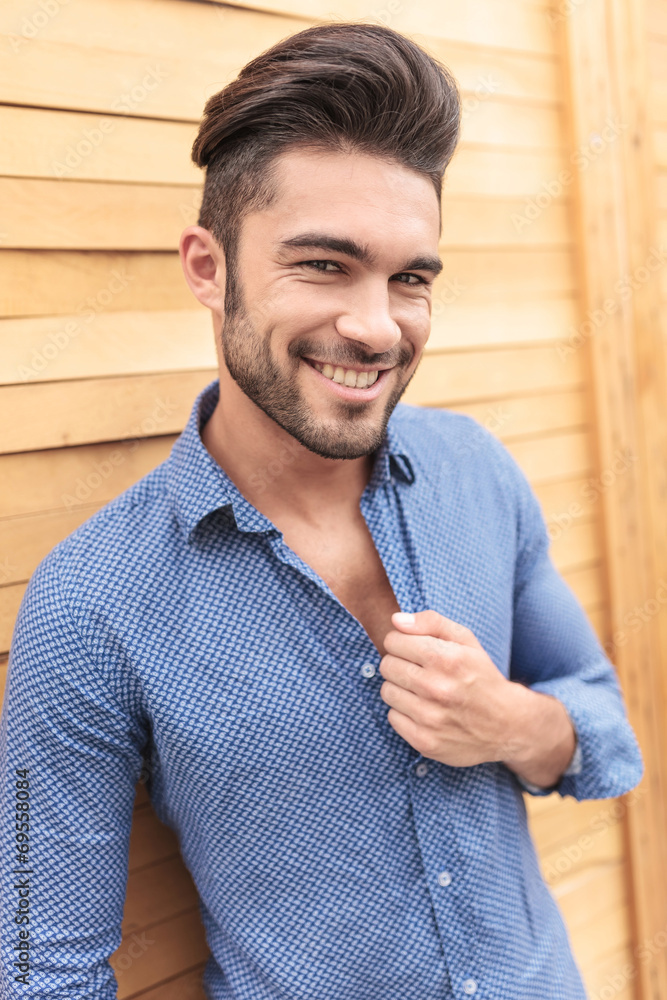 smiling casual young man is holding his collar 스톡 사진 | Adobe Stock