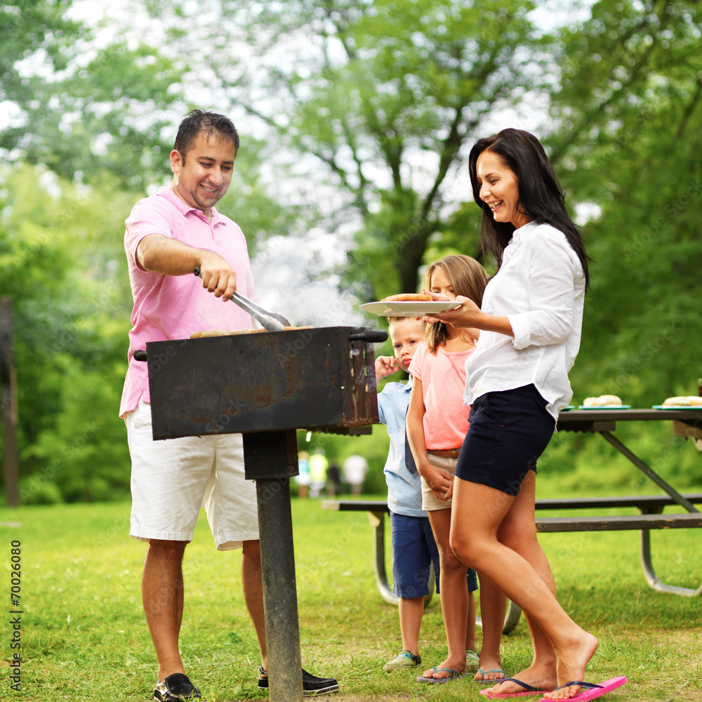 dad dishing out cooked food at family cookout Stock Photo | Adobe Stock