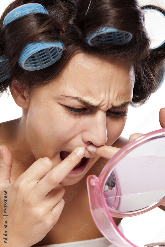 young woman with curlers squeezing pimple on her mustache Stock Photo ...