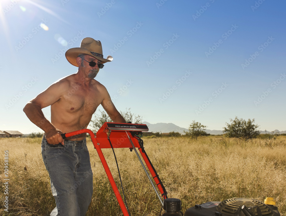 A Shirtless Cowboy Operates a Brush Mower on the Ranch Stock Photo ...