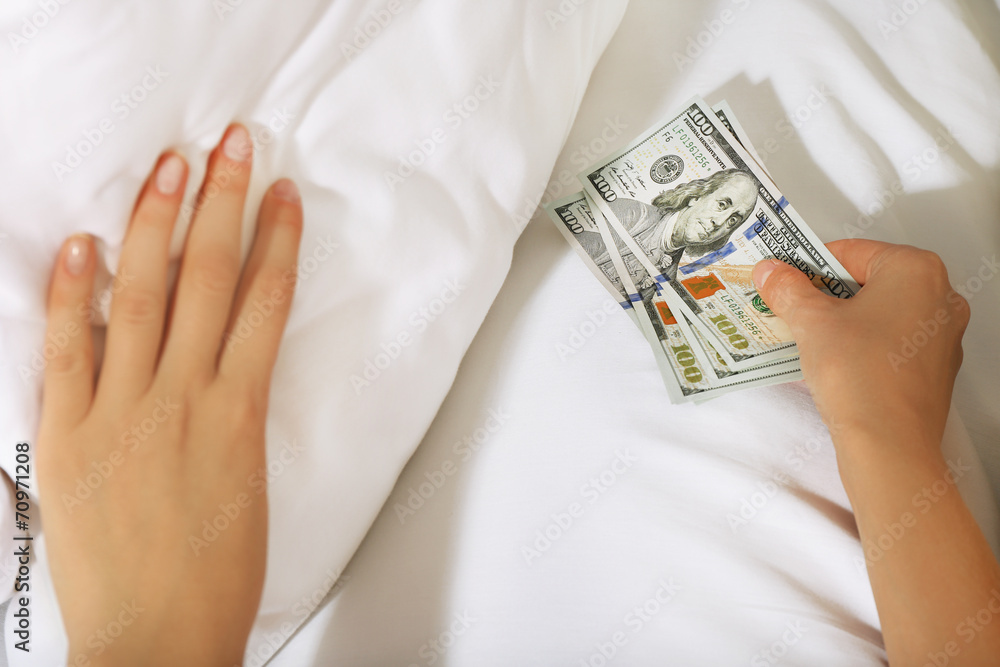Woman hiding money under pillow at home Stock Photo | Adobe Stock