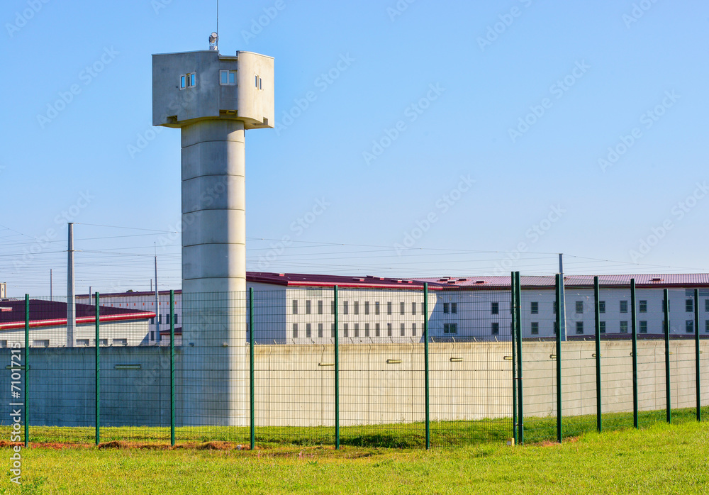 Prison area with a tall watchtower surrounded with fence Stock Photo ...
