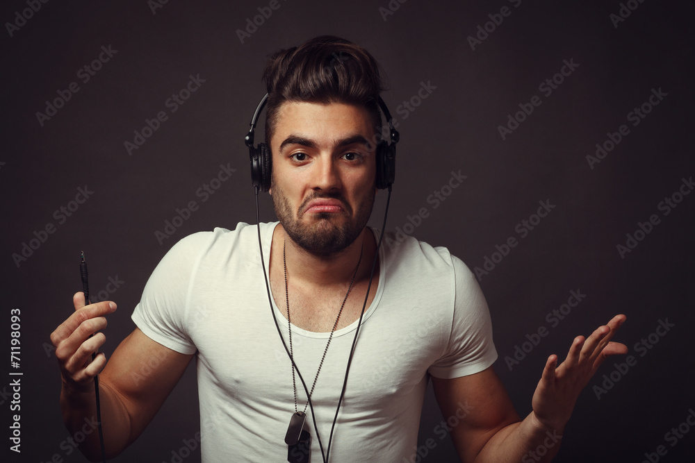 Handsome DJ posing in studio on dark background with headphones Stock ...