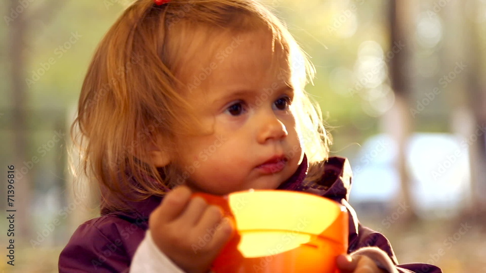 Child drinks tea in autumn park. Stock Video | Adobe Stock