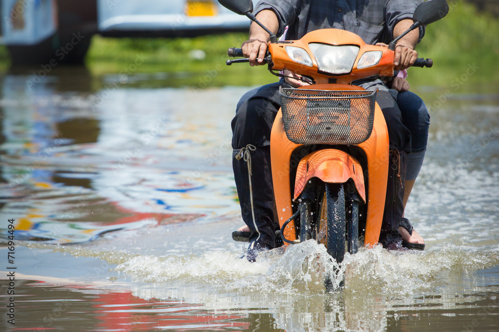 Splash by a motorcycle as it goes through flood water Stock Photo ...