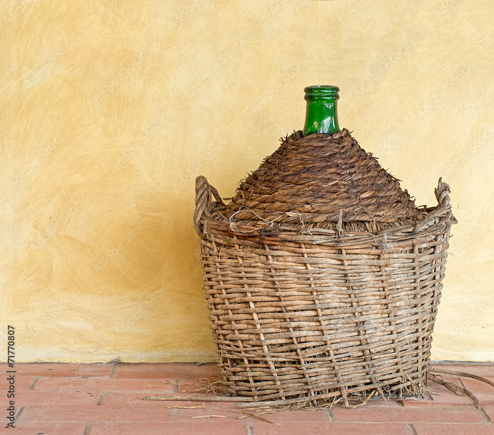 Old demijohn aka carboy for wine, wicker straw wrap, by house. Stock ...