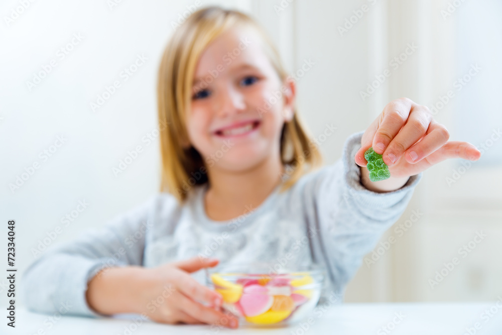 Beautiful child eating sweets at home. Stock Photo | Adobe Stock