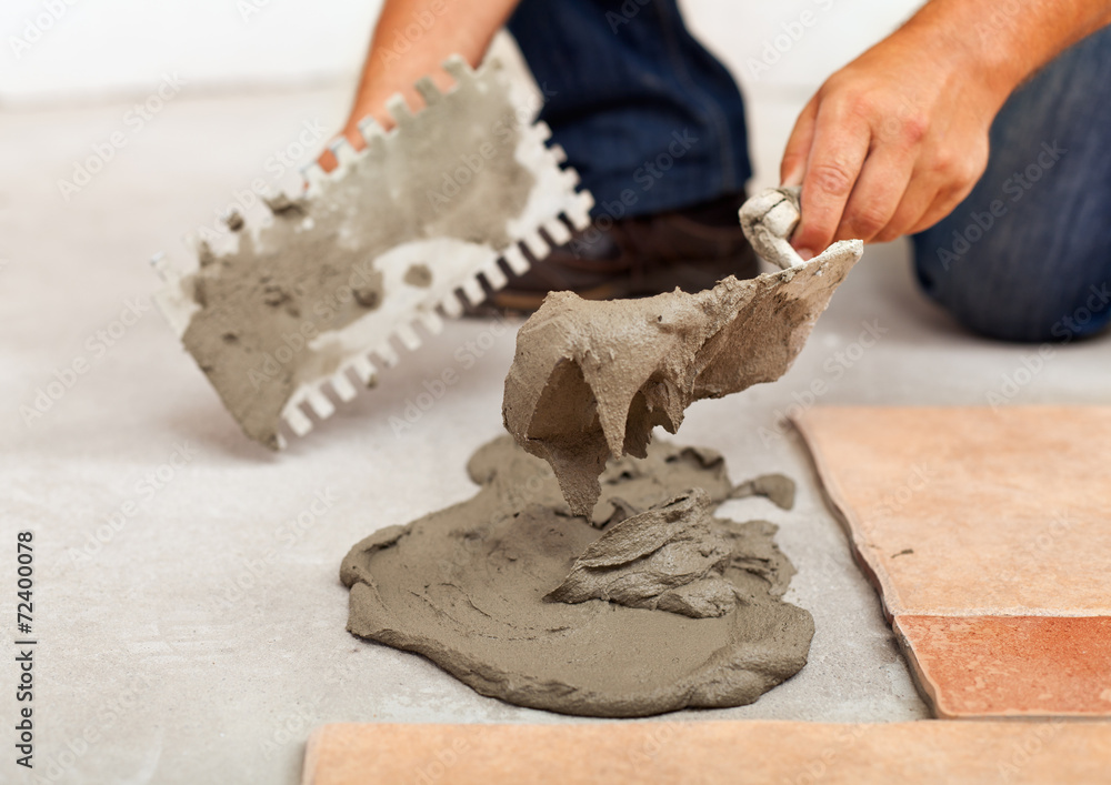 Phases of installing ceramic floor tiles - apply the adhesive Stock ...