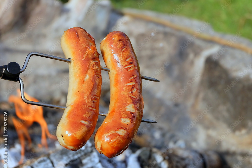 Stockfoto Wurst Grillen am Lagerfeuer mit Grillspieß | Adobe Stock