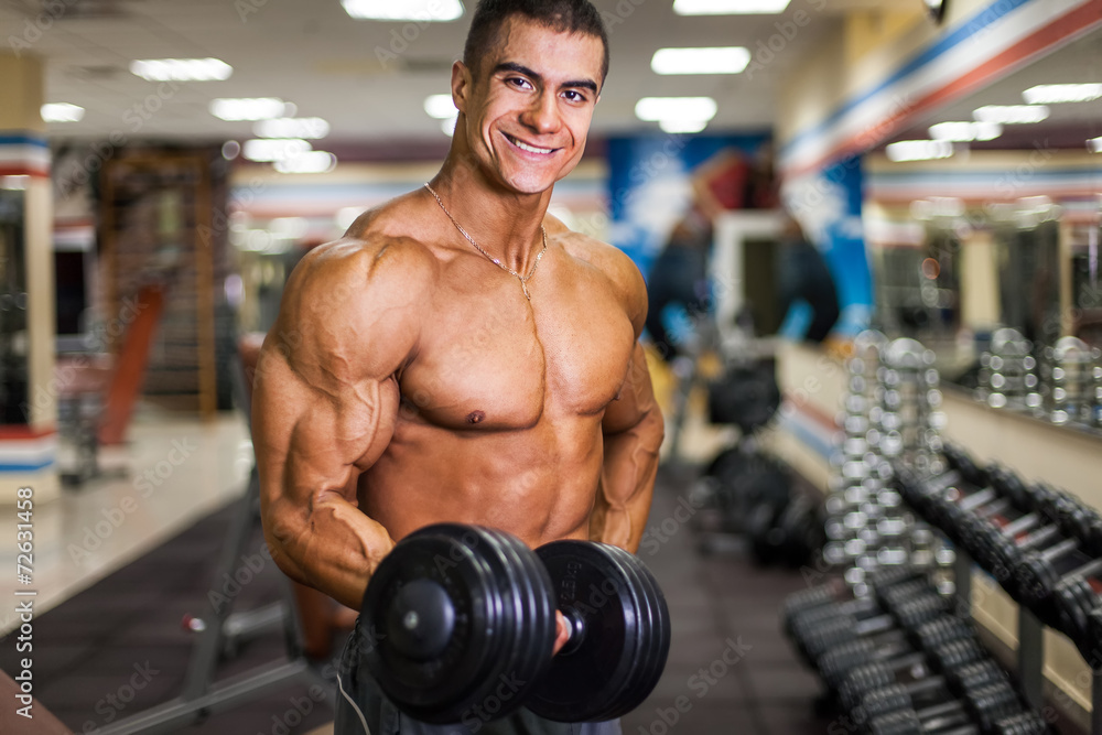 bodybuinder with dumbbell in gym Photos | Adobe Stock