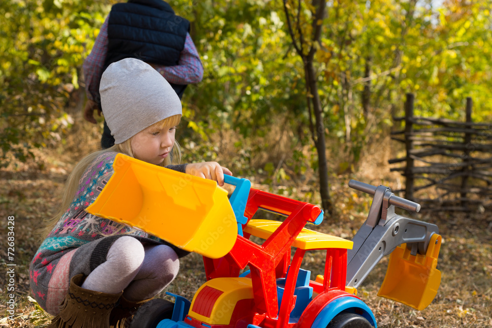 Little girl playing with a front end loader Stock Photo | Adobe Stock