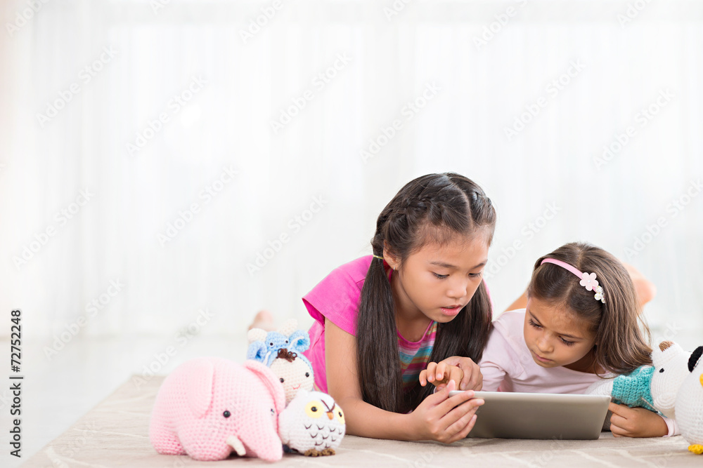 Two interested little girls using tablet computer Stock Photo | Adobe Stock