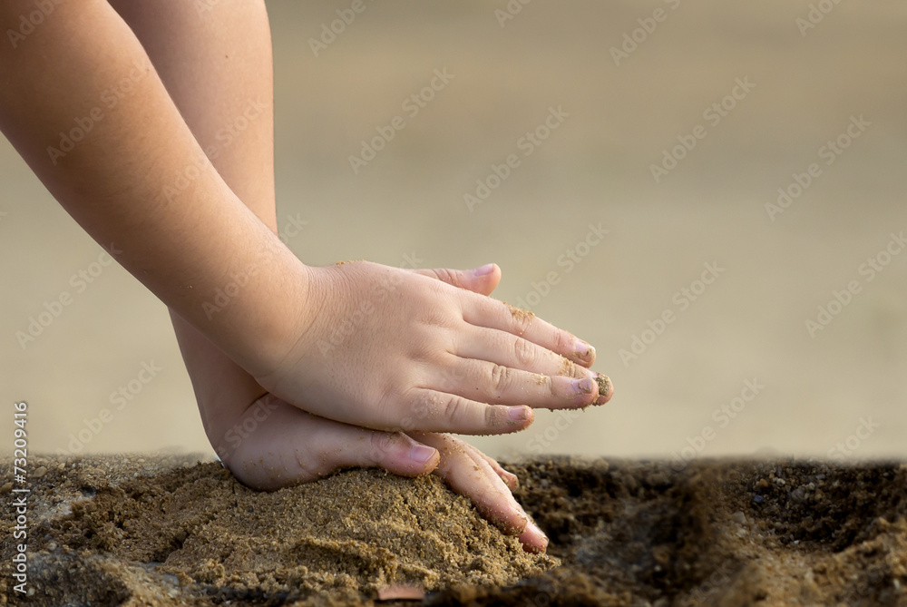 Child piling up the sand, so pat and press sand with two hand.cr Stock ...