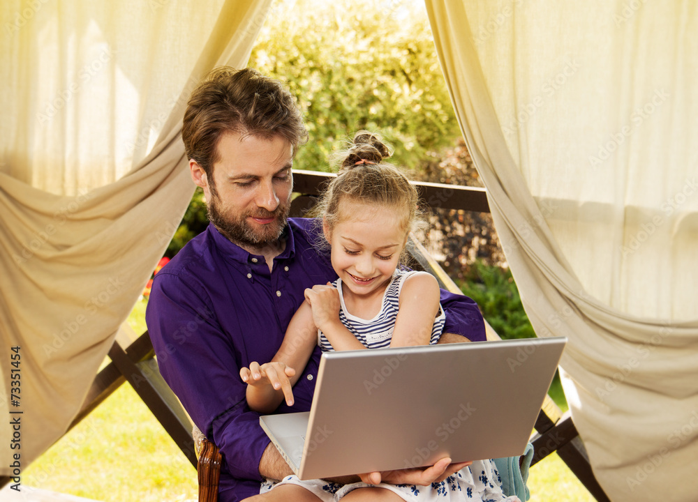 Father and daughter playing game on laptop computer outdoor Stock Photo ...