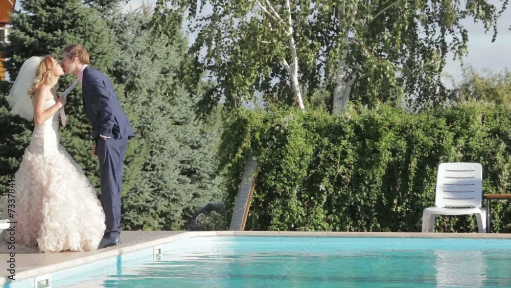 Bride pushing groom in the swimming pool Stock ビデオ | Adobe Stock