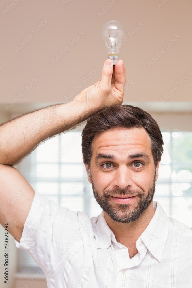 Man holding light bulb over his head Stock Photo | Adobe Stock