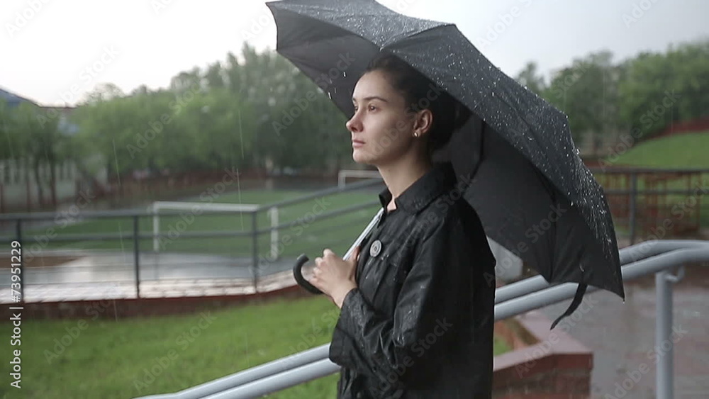 Lonely sad woman in heavy rain under an umbrella slow motion Stock ...