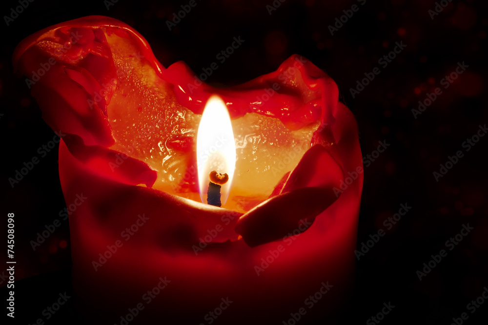 red candle with flame and melting wax against a dark background Stock ...