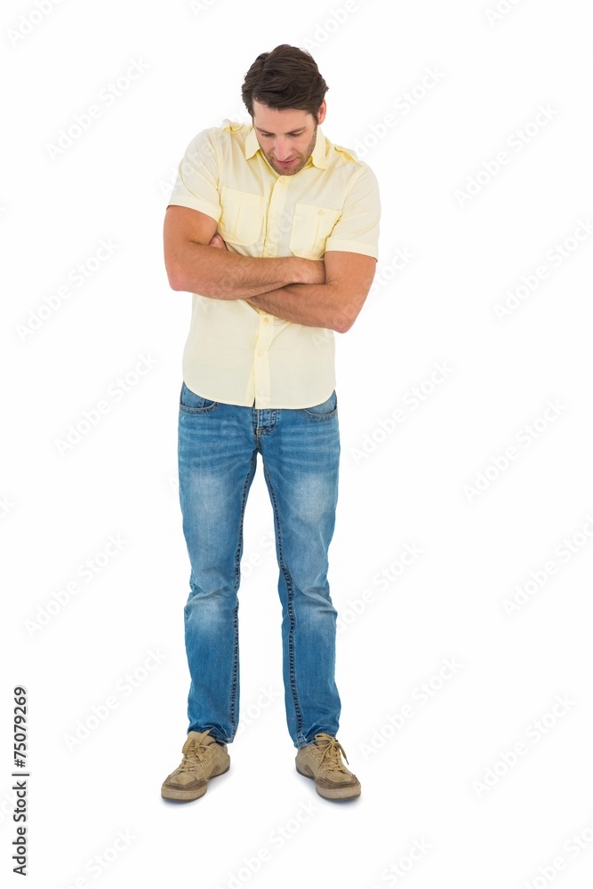 Handsome man standing looking down with arm crossed Stock Photo | Adobe ...