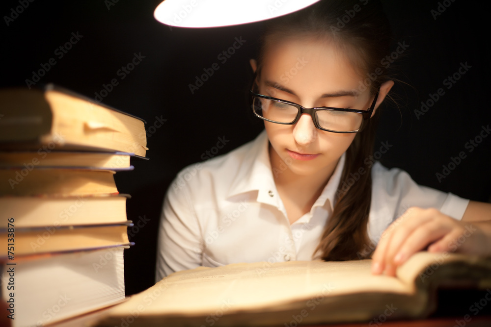 Young girl reading book under lamp Stock Photo | Adobe Stock