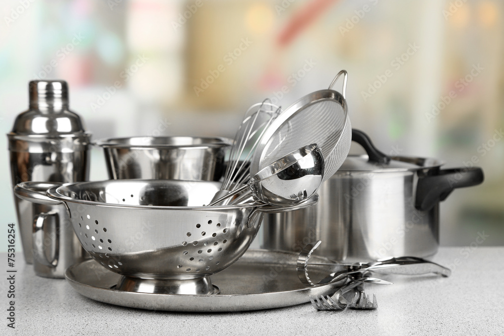 Stainless steel kitchenware on table, on light background Stock Photo ...