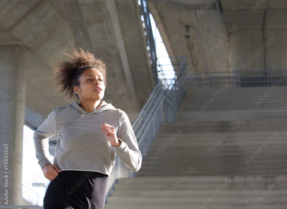 Young black woman jogging outdoors Stock Photo | Adobe Stock