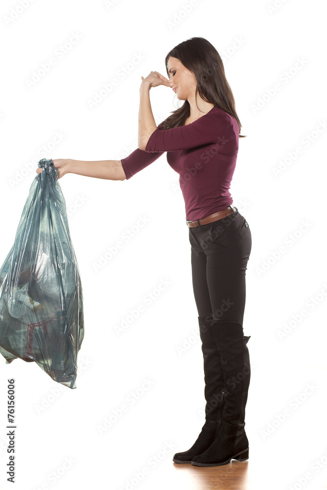 disgusted young woman holding garbage bag and squeezes her nose Stock ...