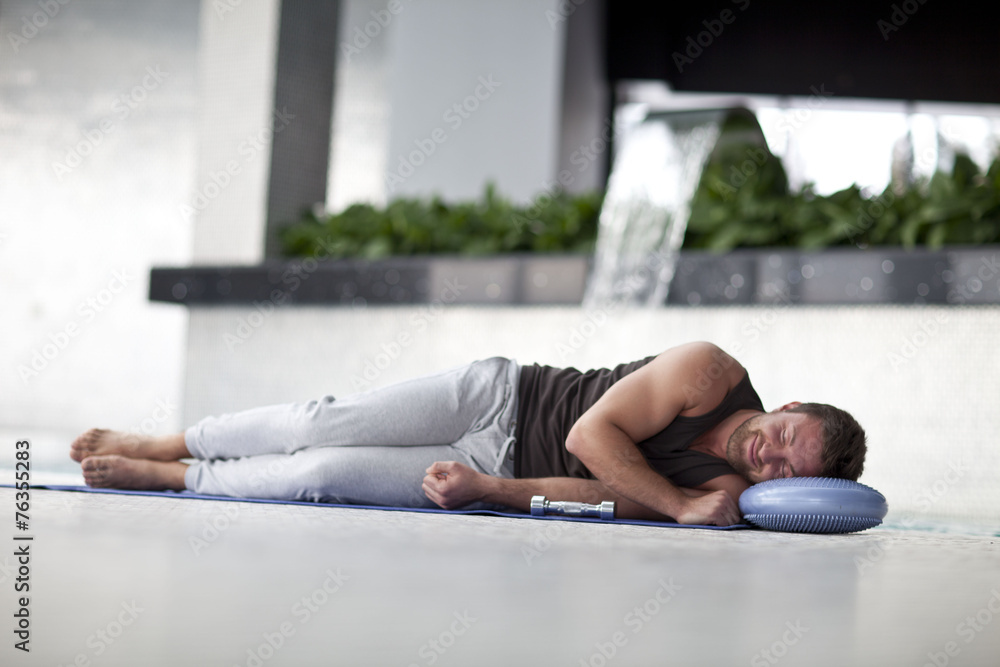 Foto de Side view man sleeping on exercise ball in health club do Stock ... Foto de Side view man sleeping on exercise ball in health club do Stock ...